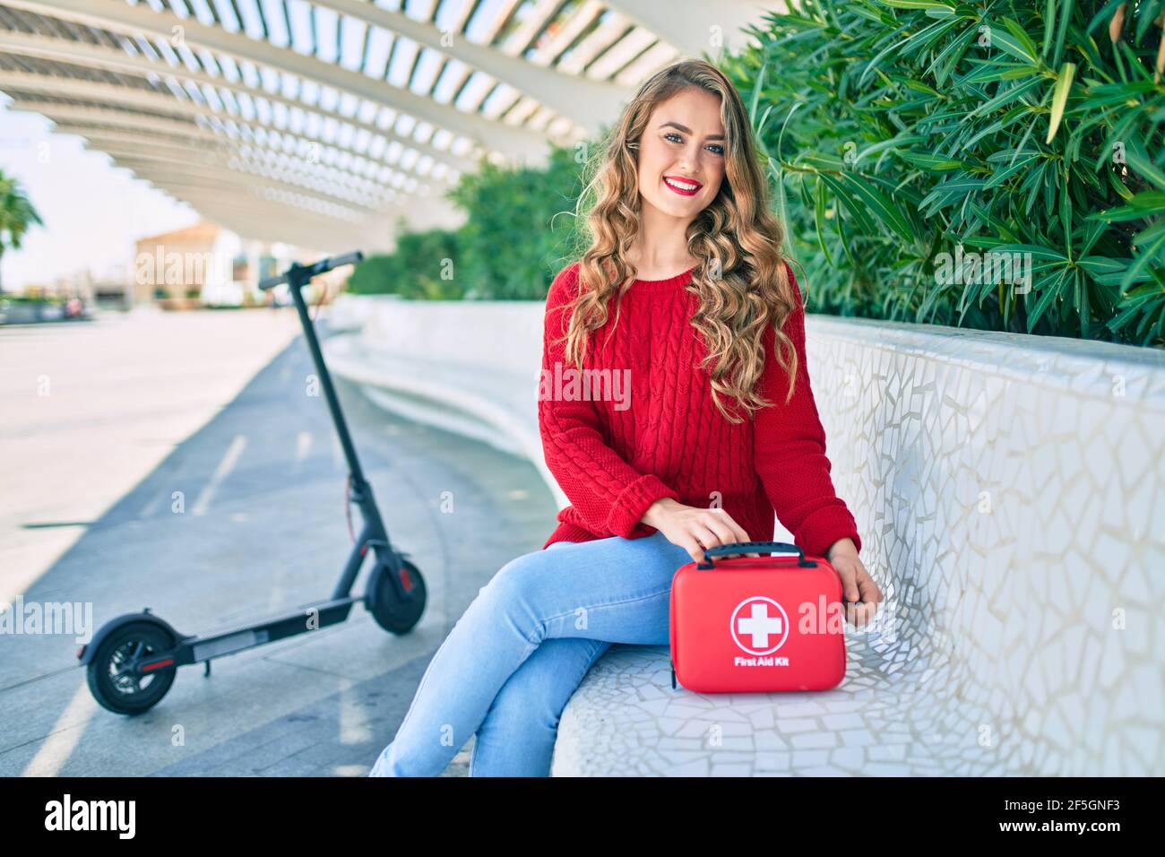 Young blonde girl smiling happy opening first aid kit sitting on the ...