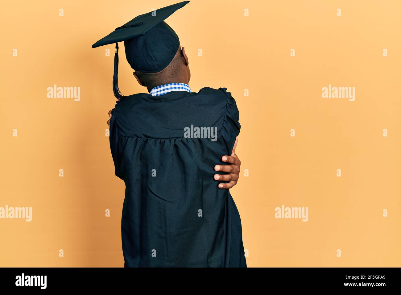 Young african american man wearing graduation cap and ceremony robe ...