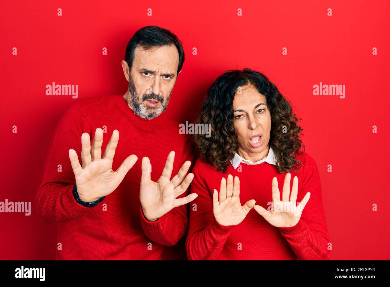 Middle age couple of hispanic woman and man hugging and standing ...