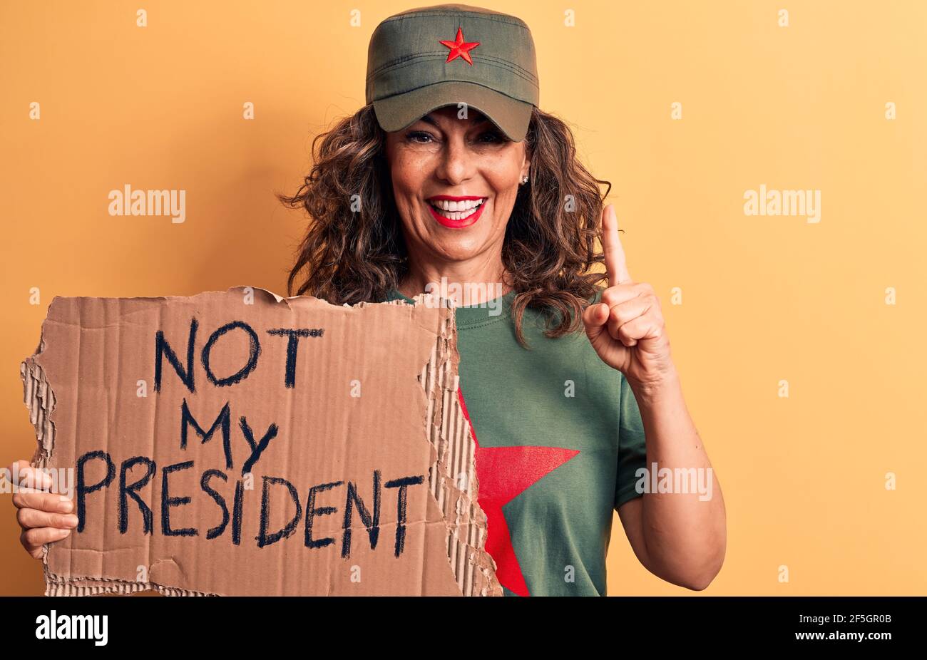Middle age brunette communist woman holding banner with not my ...