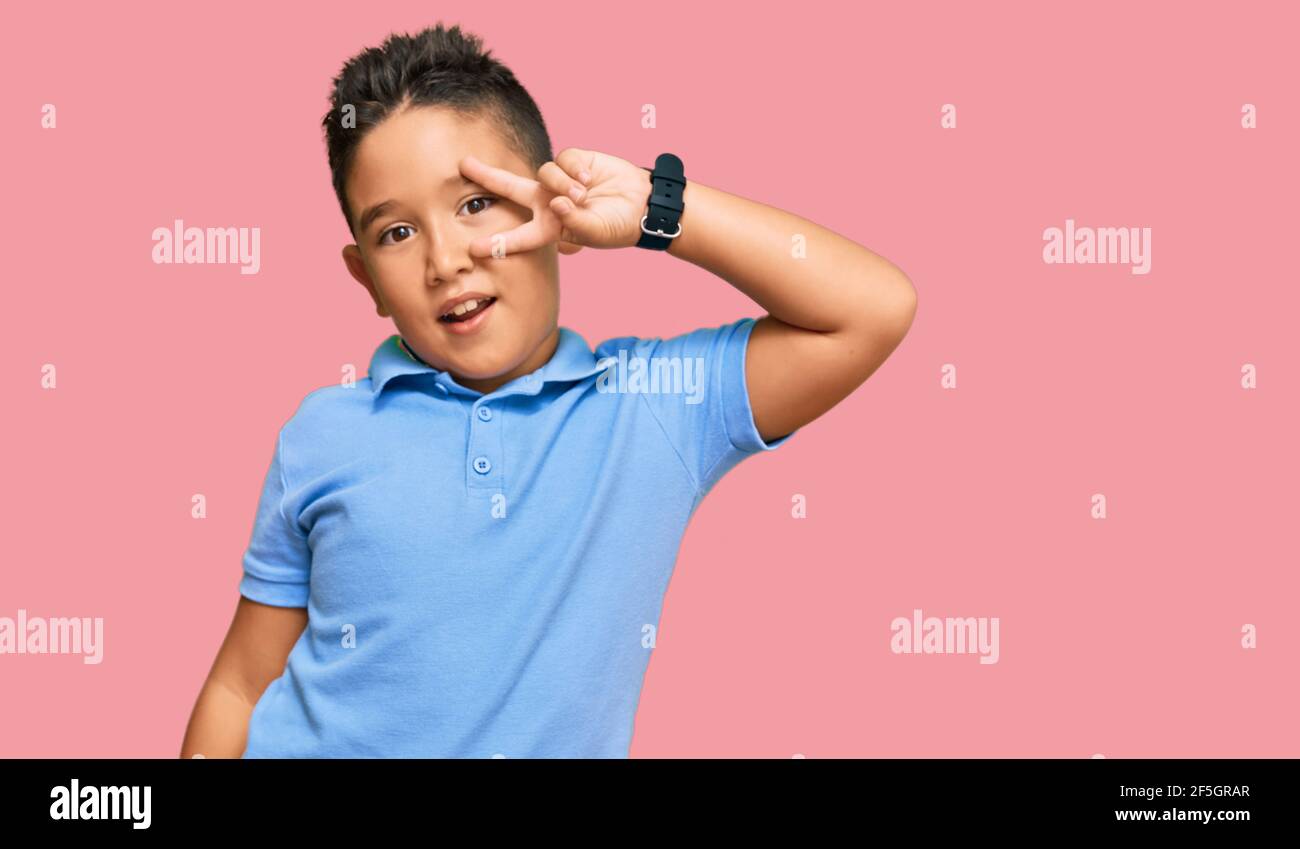 Little boy hispanic kid wearing casual clothes doing peace symbol with ...