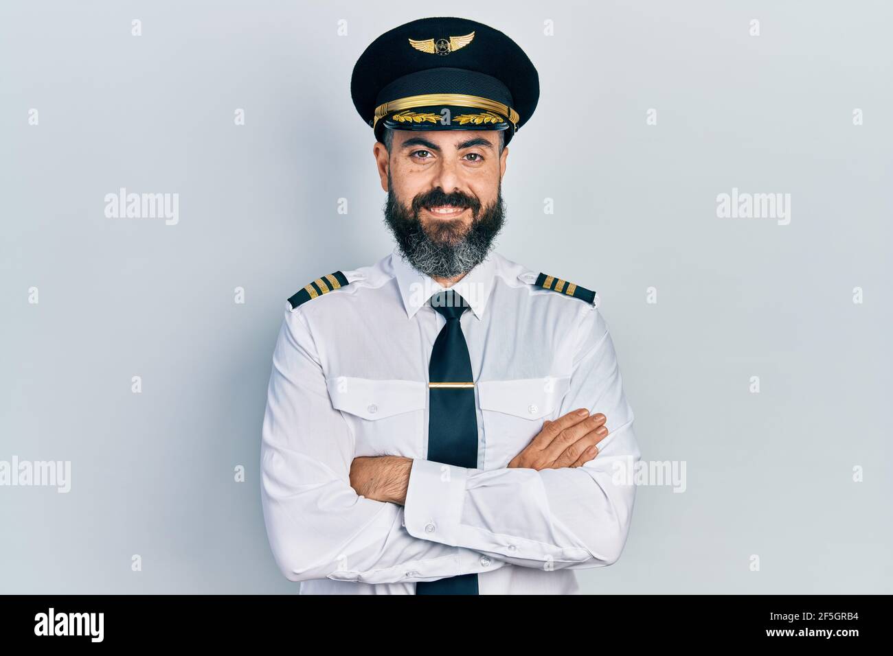 Young hispanic man wearing airplane pilot uniform happy face smiling ...