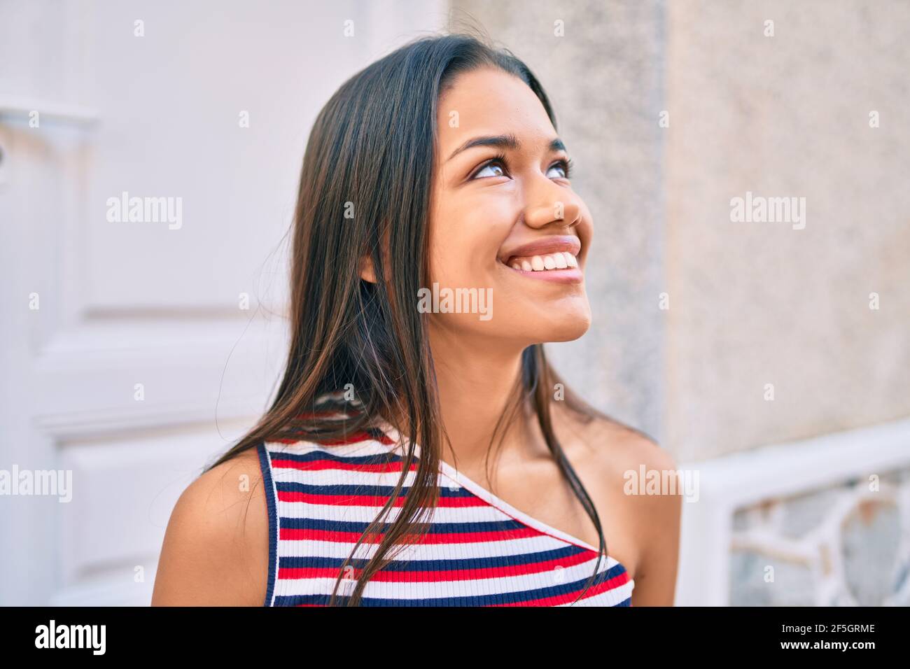 Young latin girl smiling happy walking at the city Stock Photo - Alamy