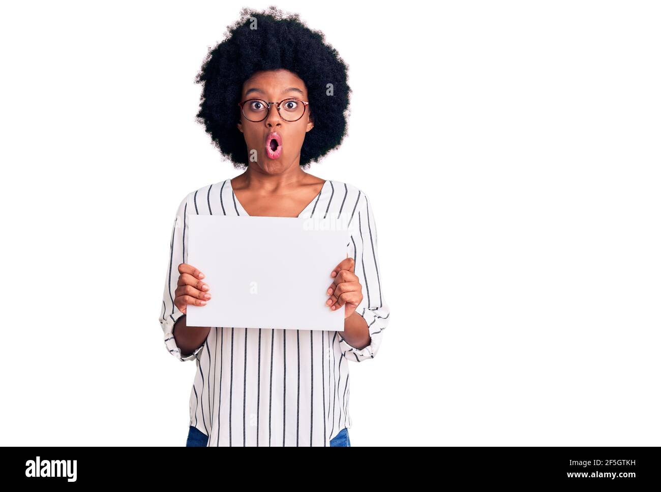 Young african american woman holding blank empty paper scared and ...