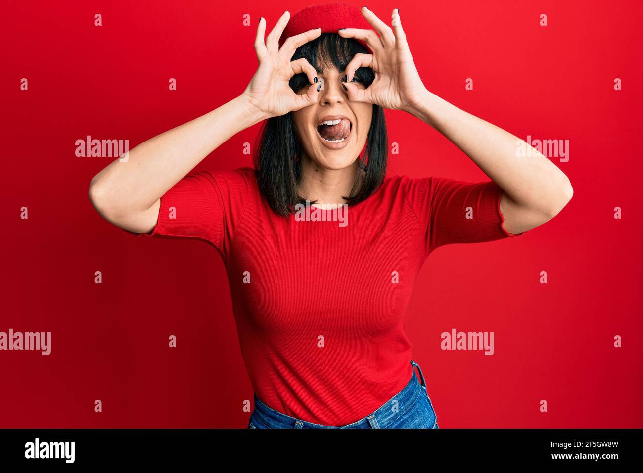 Young hispanic woman wearing french look with beret doing ok gesture ...