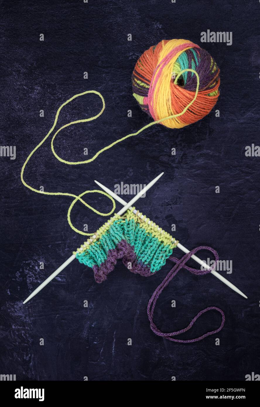 Multi coloured wool with knitting on textured background Stock Photo ...