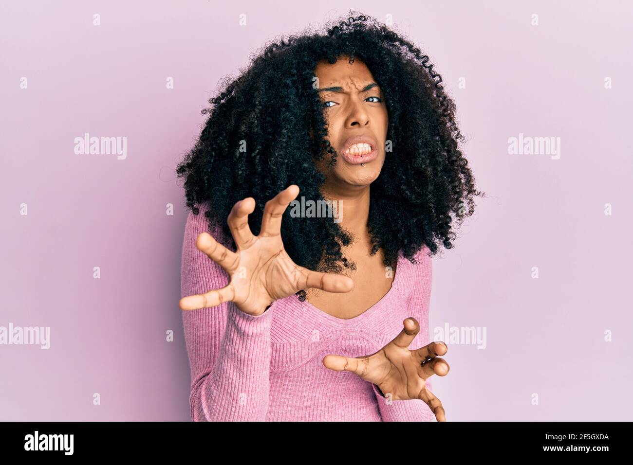 African american woman with afro hair wearing casual pink shirt ...