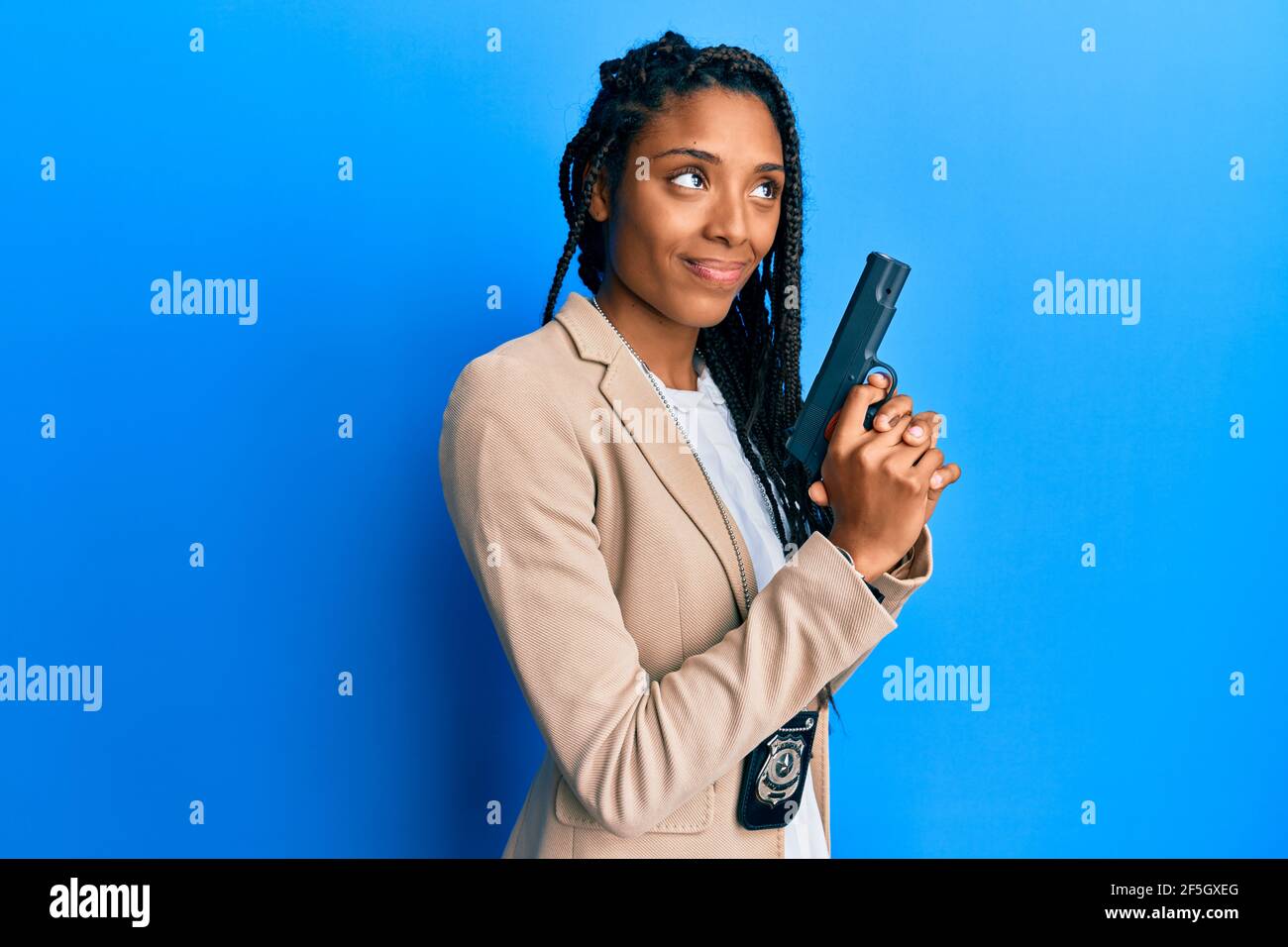 African american police woman holding gun smiling looking to the side ...