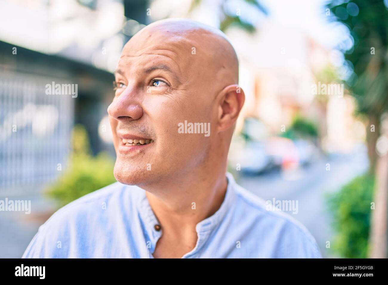 Middle age bald man smiling happy walking at the city Stock Photo - Alamy