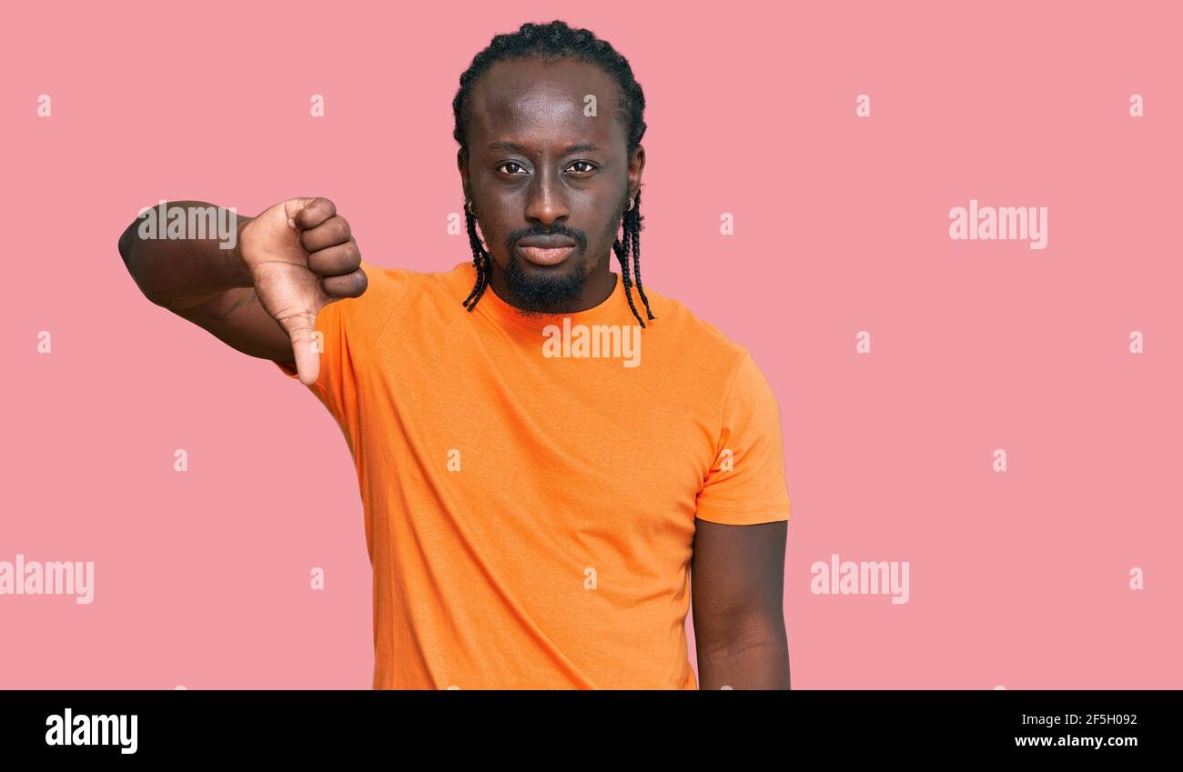 Handsome young african american man wearing casual clothes looking unhappy and angry showing ...