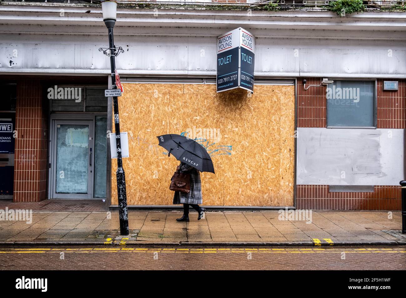 London UK, March 26 2021, Woman Alone Walking Past Closed Retail Shop ...