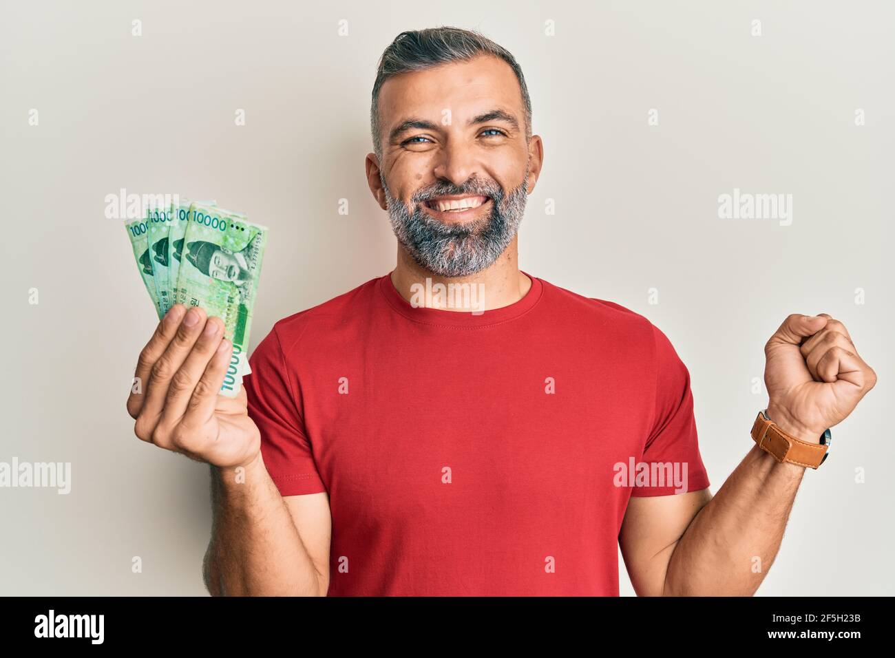 Middle age handsome man holding 10000 south korean won banknotes ...