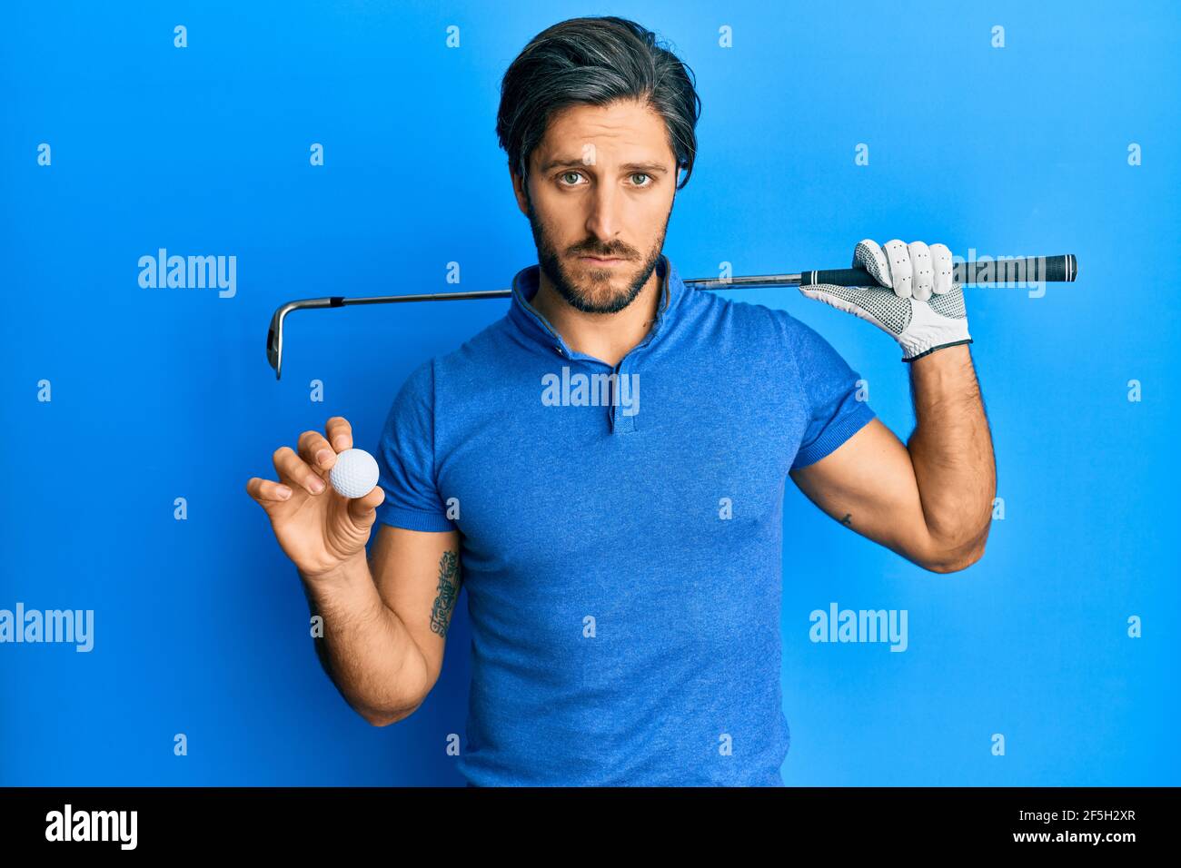 Young hispanic man holding golf ball depressed and worry for distress ...