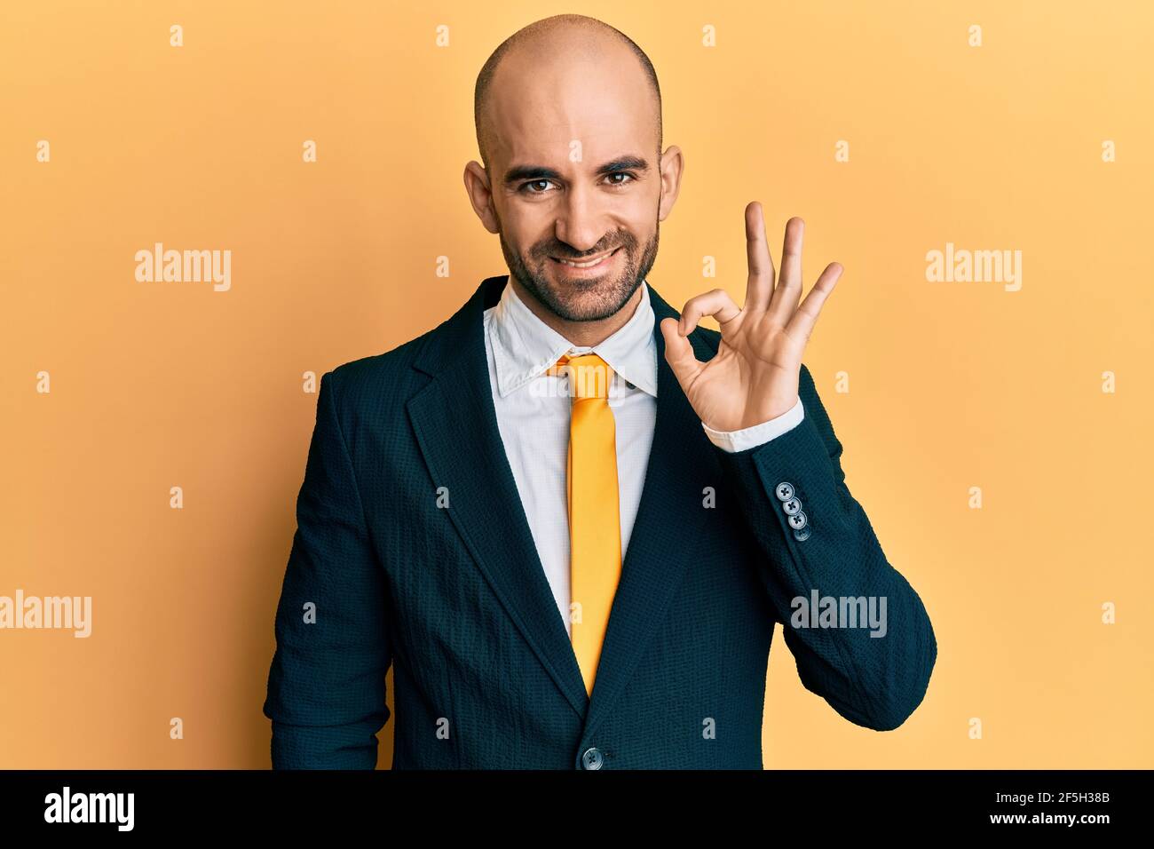 Young hispanic man wearing business suit and tie smiling positive doing ...