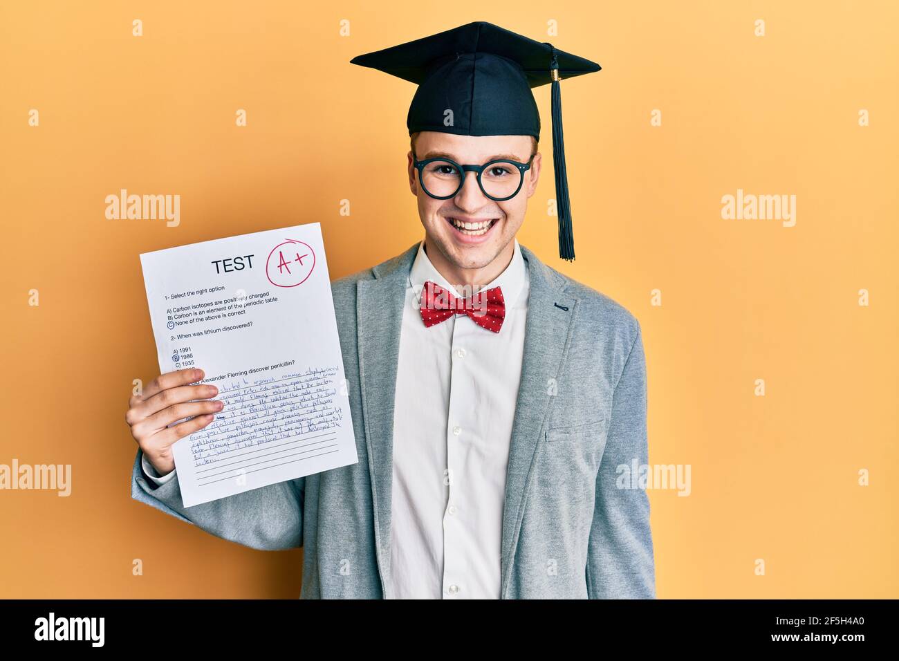Young caucasian nerd man wearing glasses and graduation cap holding ...
