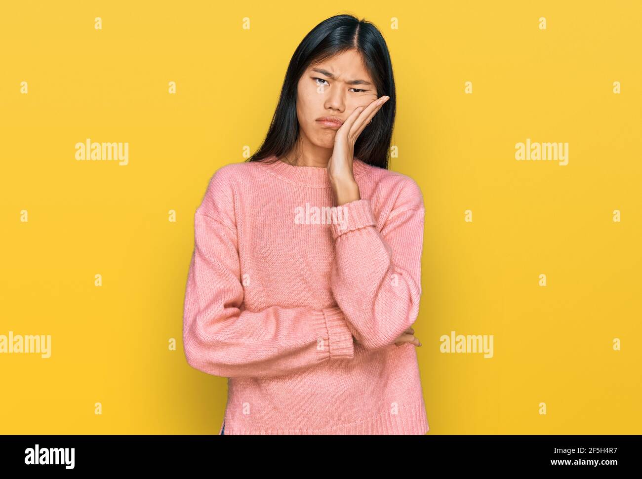 Beautiful young asian woman wearing casual winter sweater thinking ...