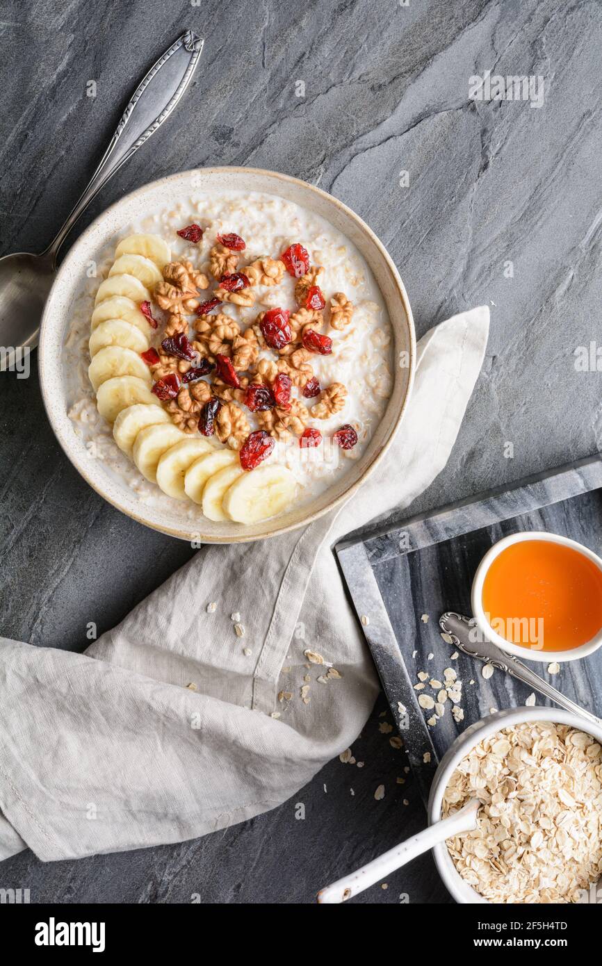 Healthy cereal breakfast, oatmeal topped with banana slices, dried ...