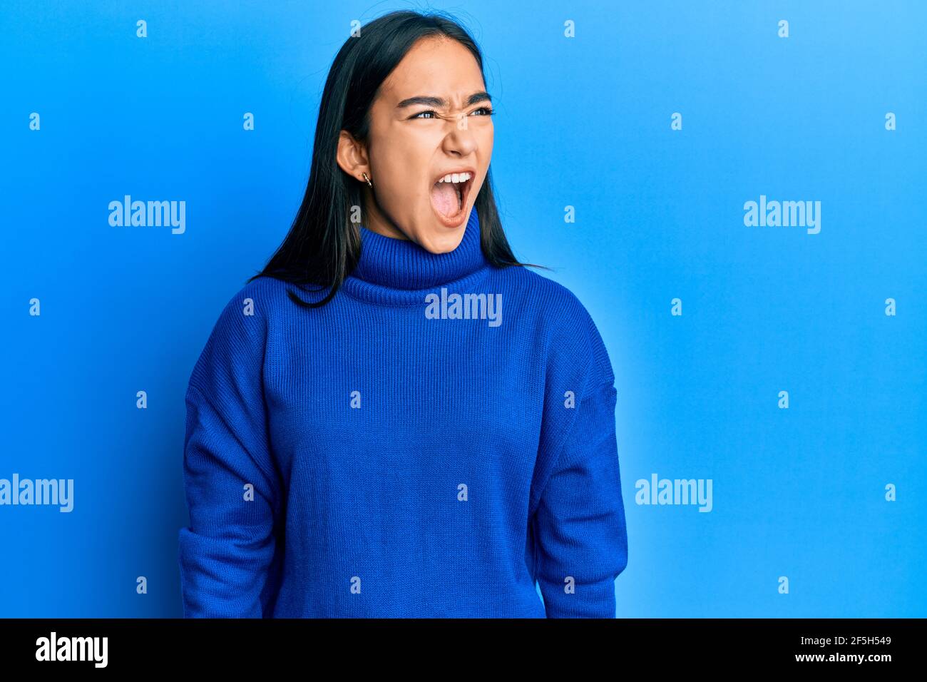 Young asian woman wearing casual winter sweater angry and mad screaming ...