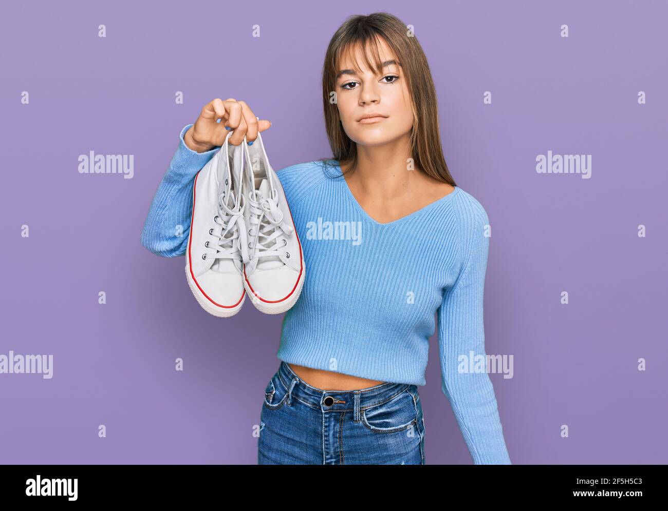 Teenager caucasian girl taking casual white shoes from box thinking ...