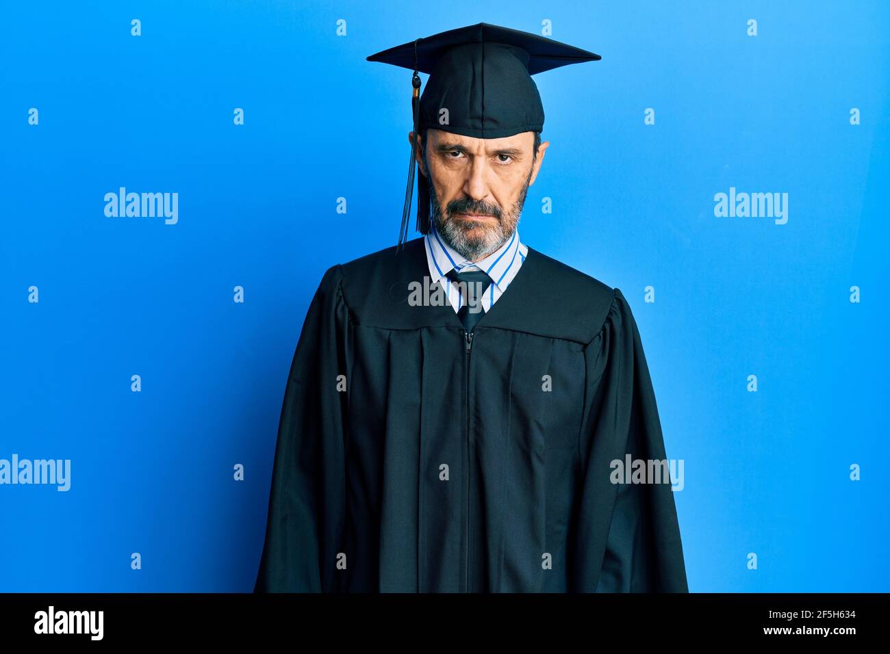 Middle age hispanic man wearing graduation cap and ceremony robe ...
