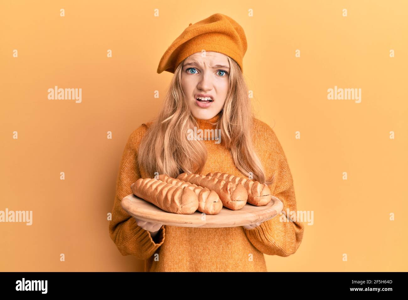 Beautiful young caucasian girl wearing french look with beret holding ...