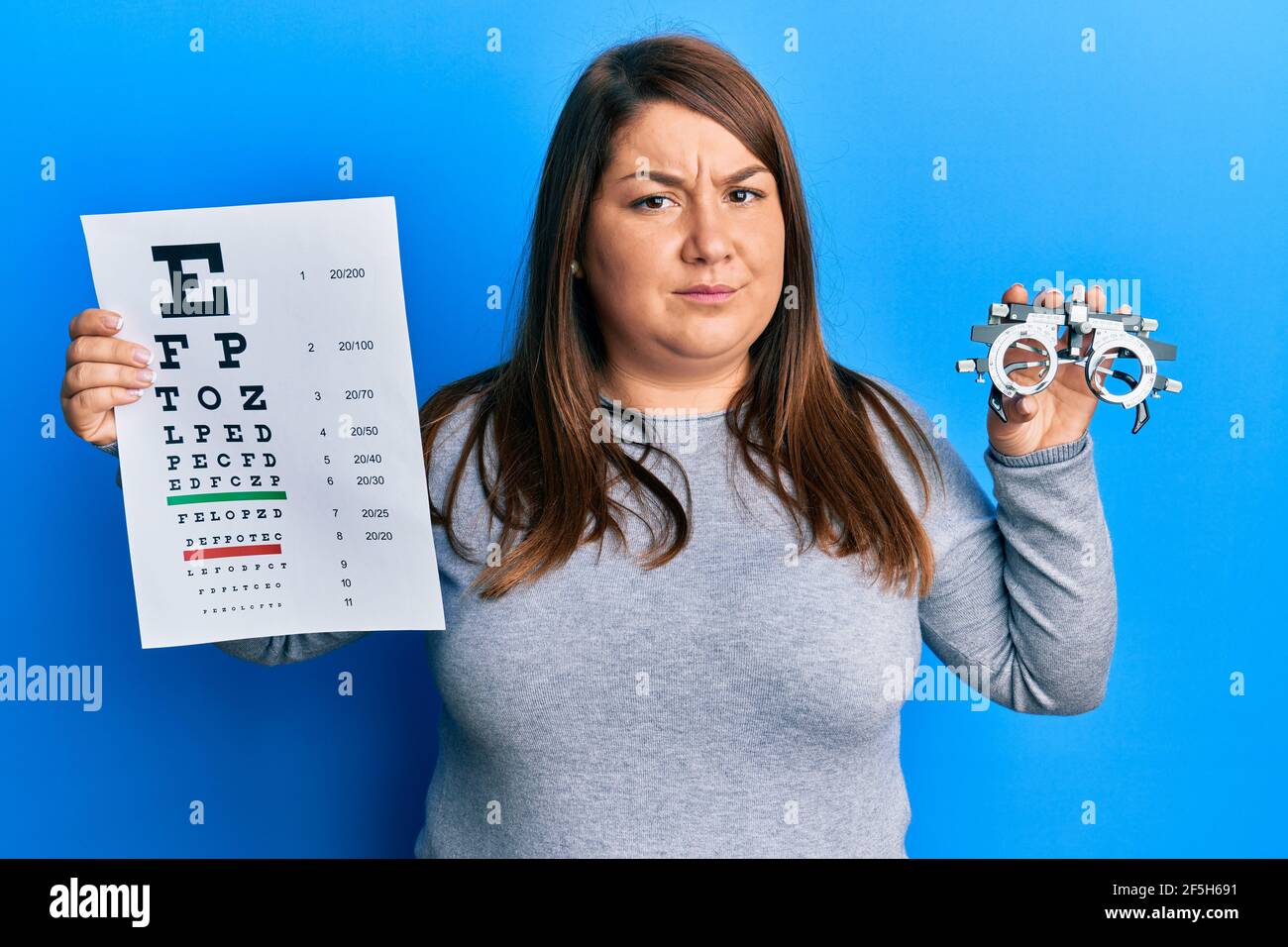 Beautiful brunette plus size woman holding optometry glasses and ...