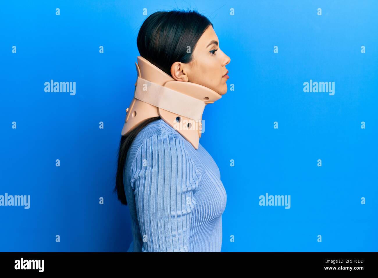 Beautiful brunette woman wearing cervical collar looking to side, relax ...