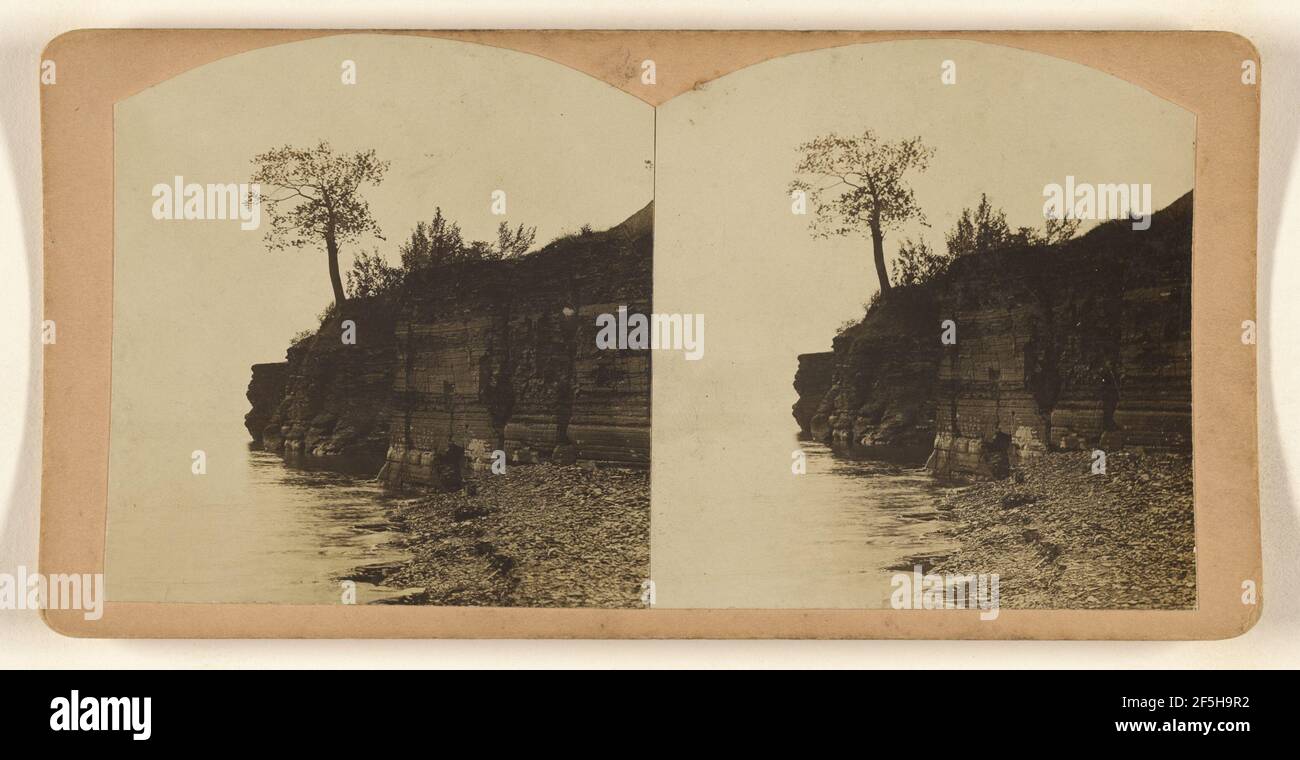 View of unidentified shoreline with cliff, beach and trees, somewhere ...