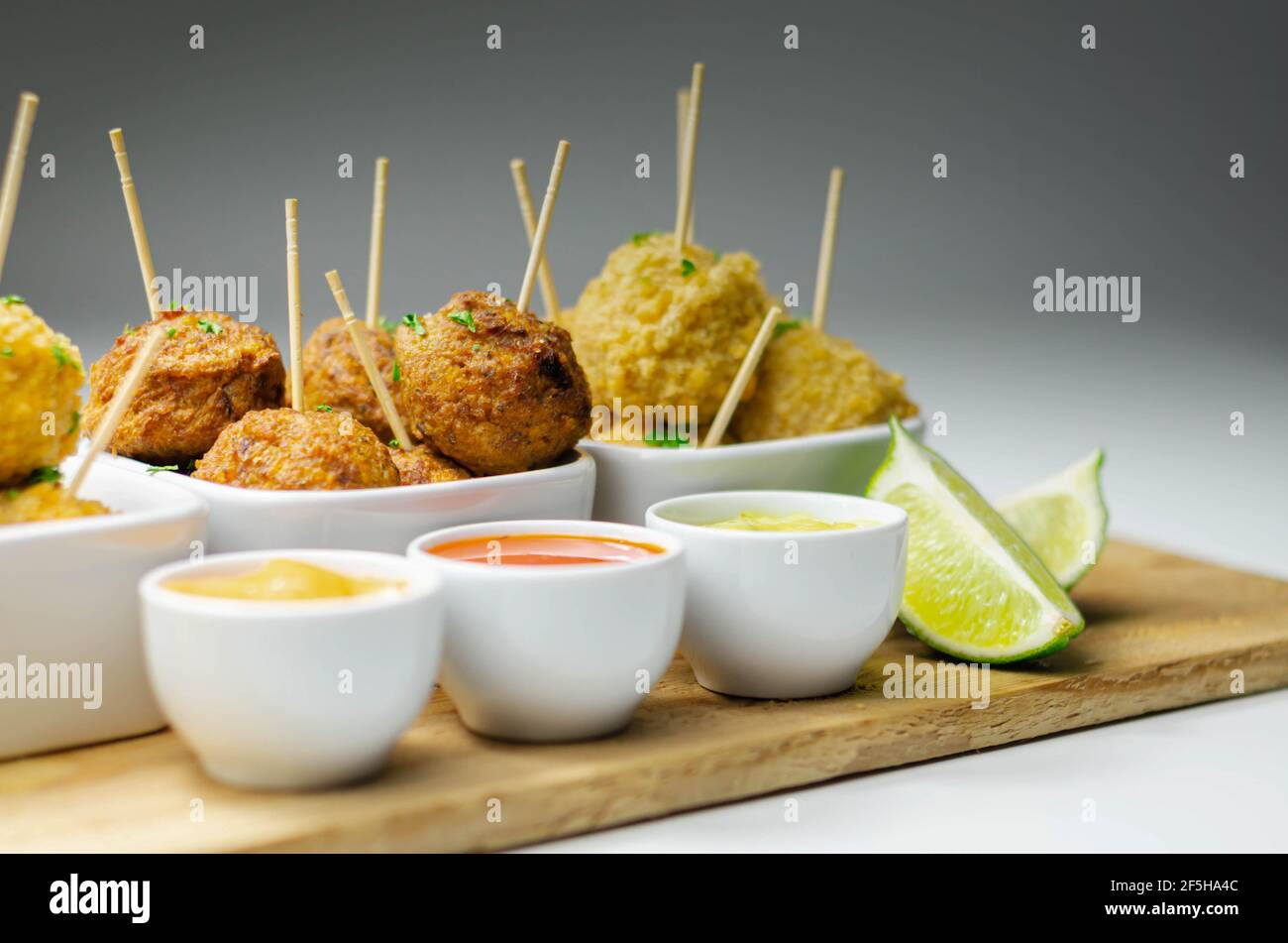 Various mini chicken kievs and sweet potato falafels served with sauces ...