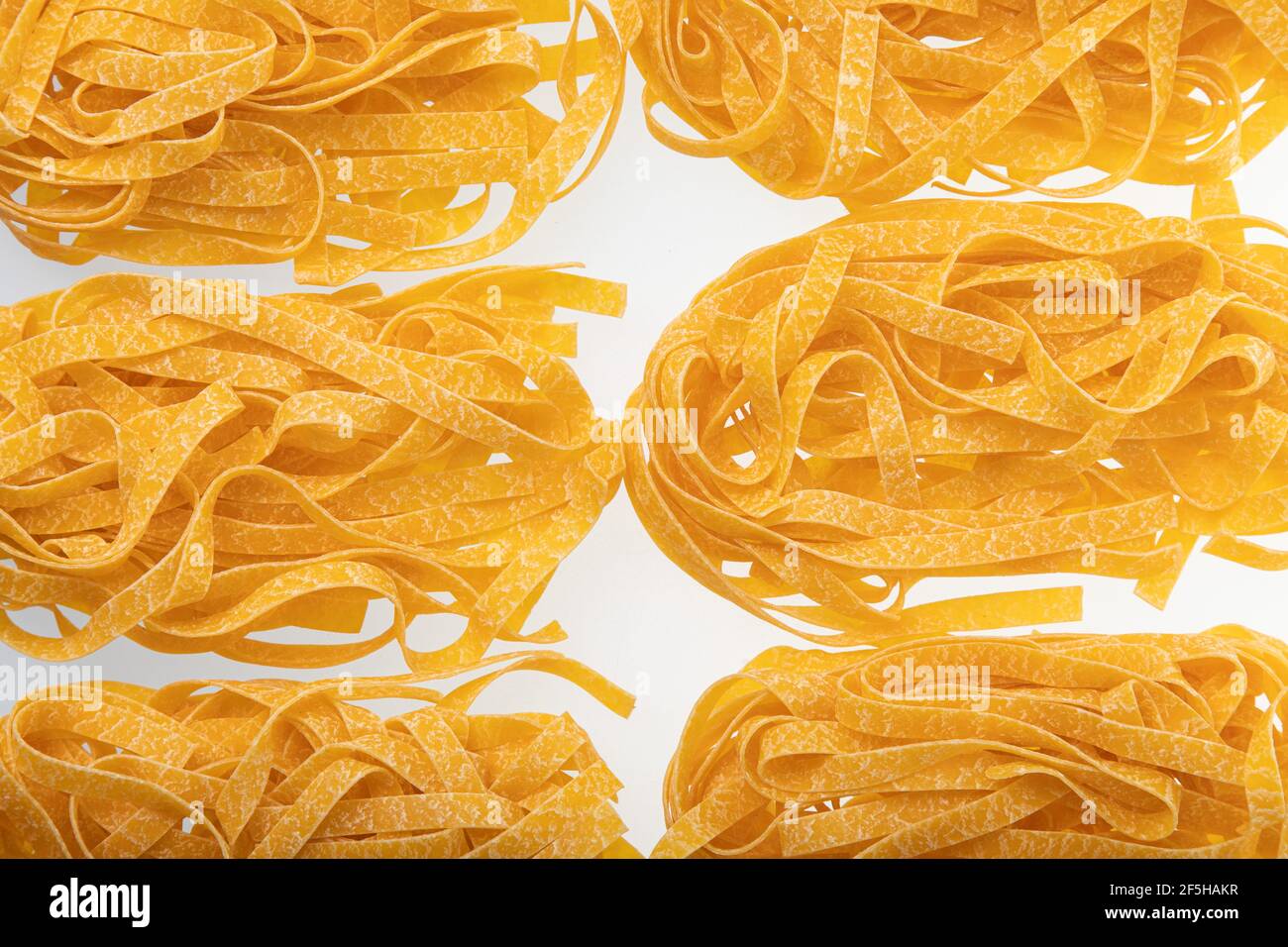 Handmade uncooked and raw egg tagliatelle isolated on white background ...