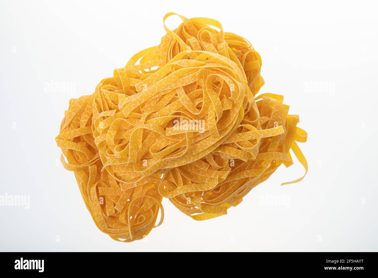 Handmade uncooked and raw egg tagliatelle isolated on white background ...