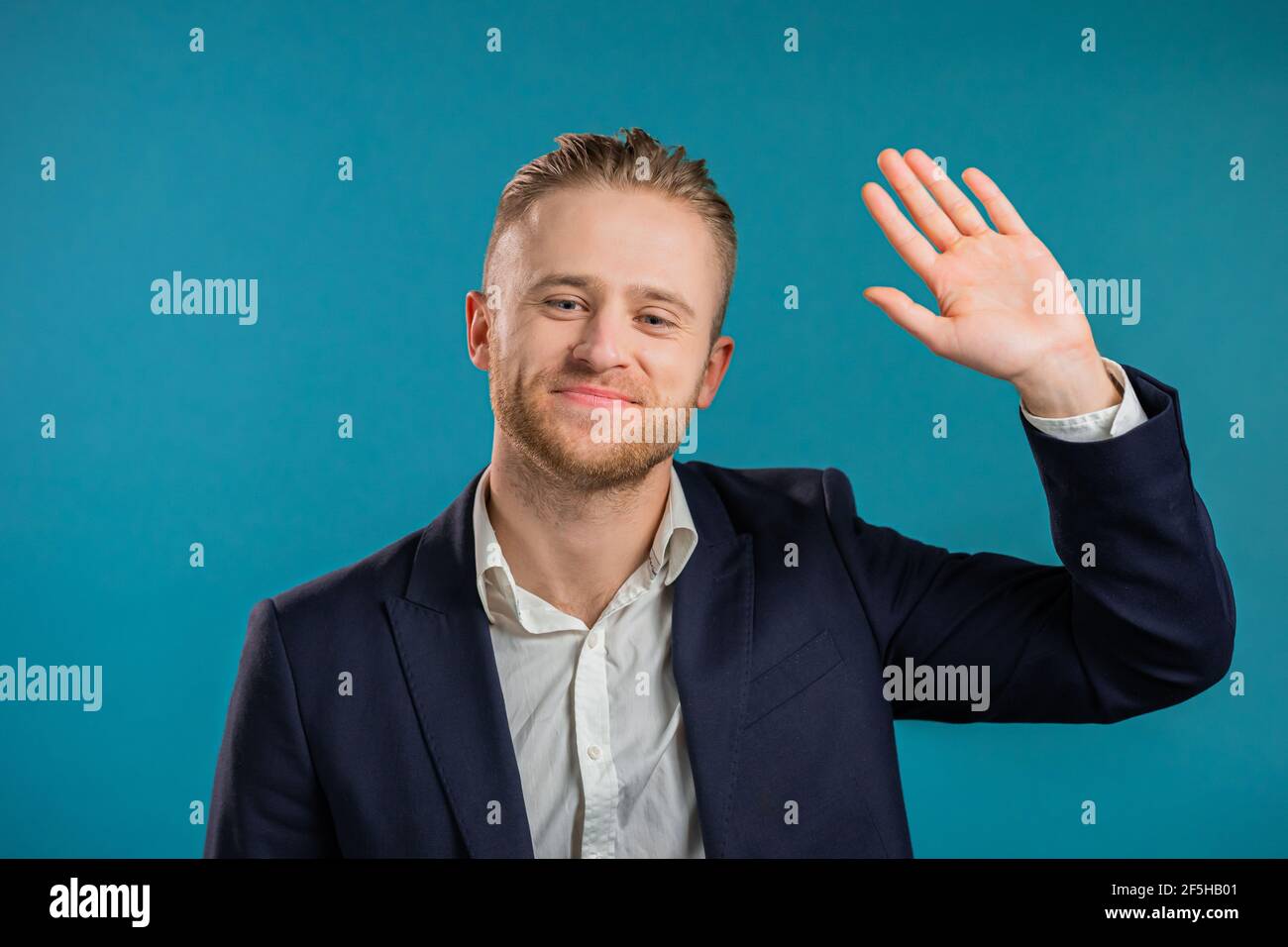 Young friendly man waving hand - hello. Greeting, say Hi to camera ...