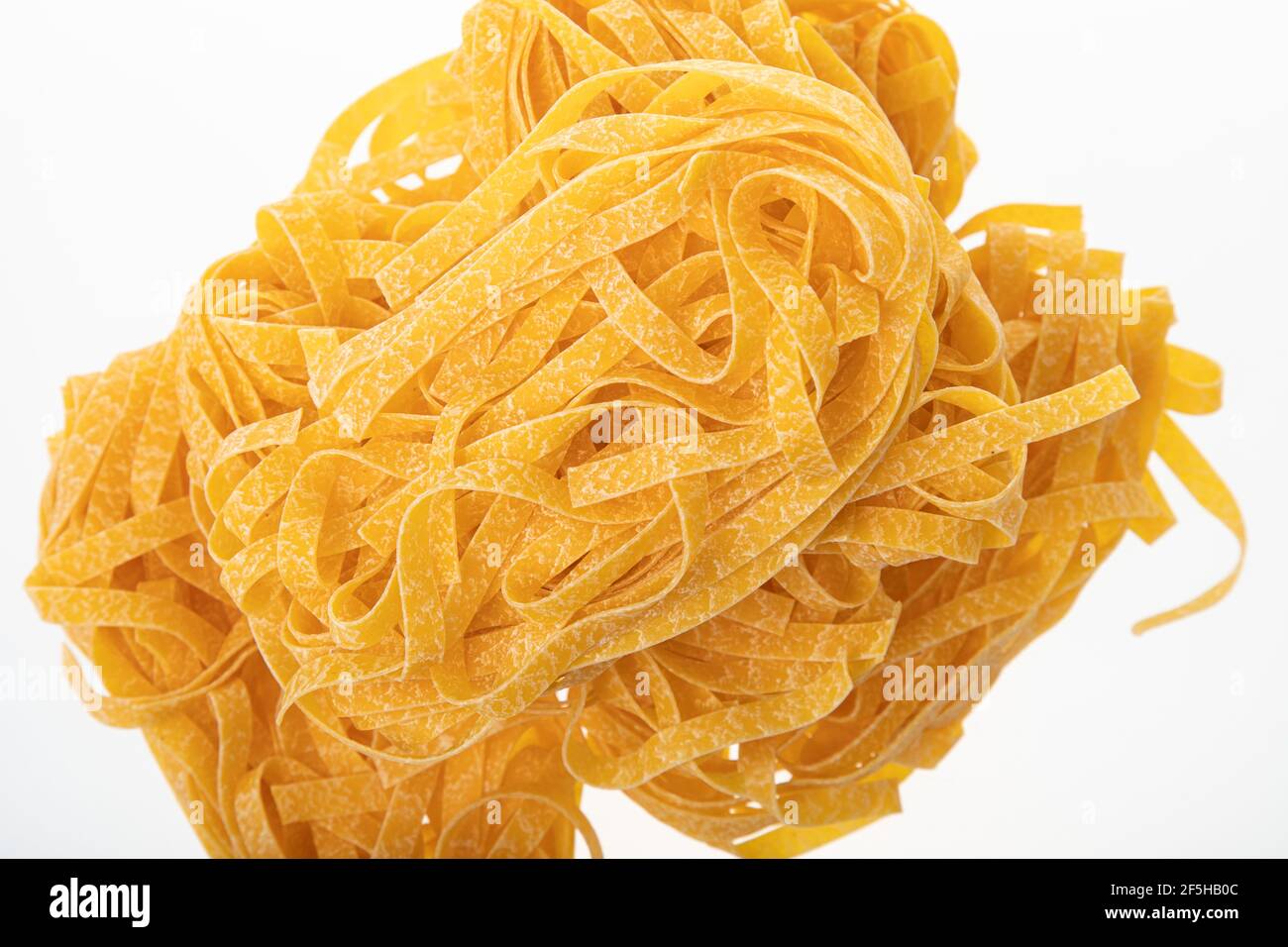 Handmade uncooked and raw egg tagliatelle isolated on white background ...
