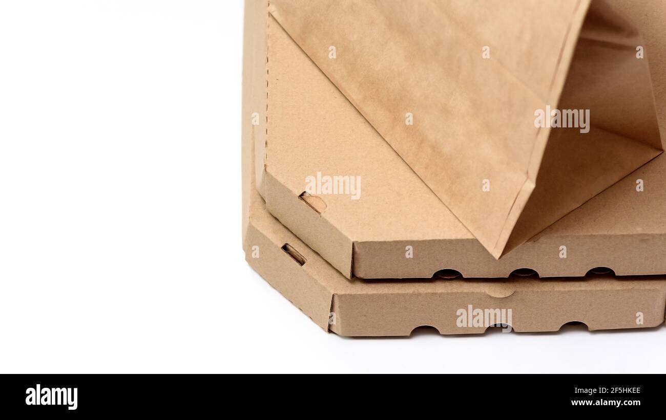 Paper bag and pizza delivery boxes on white table background, phone ...