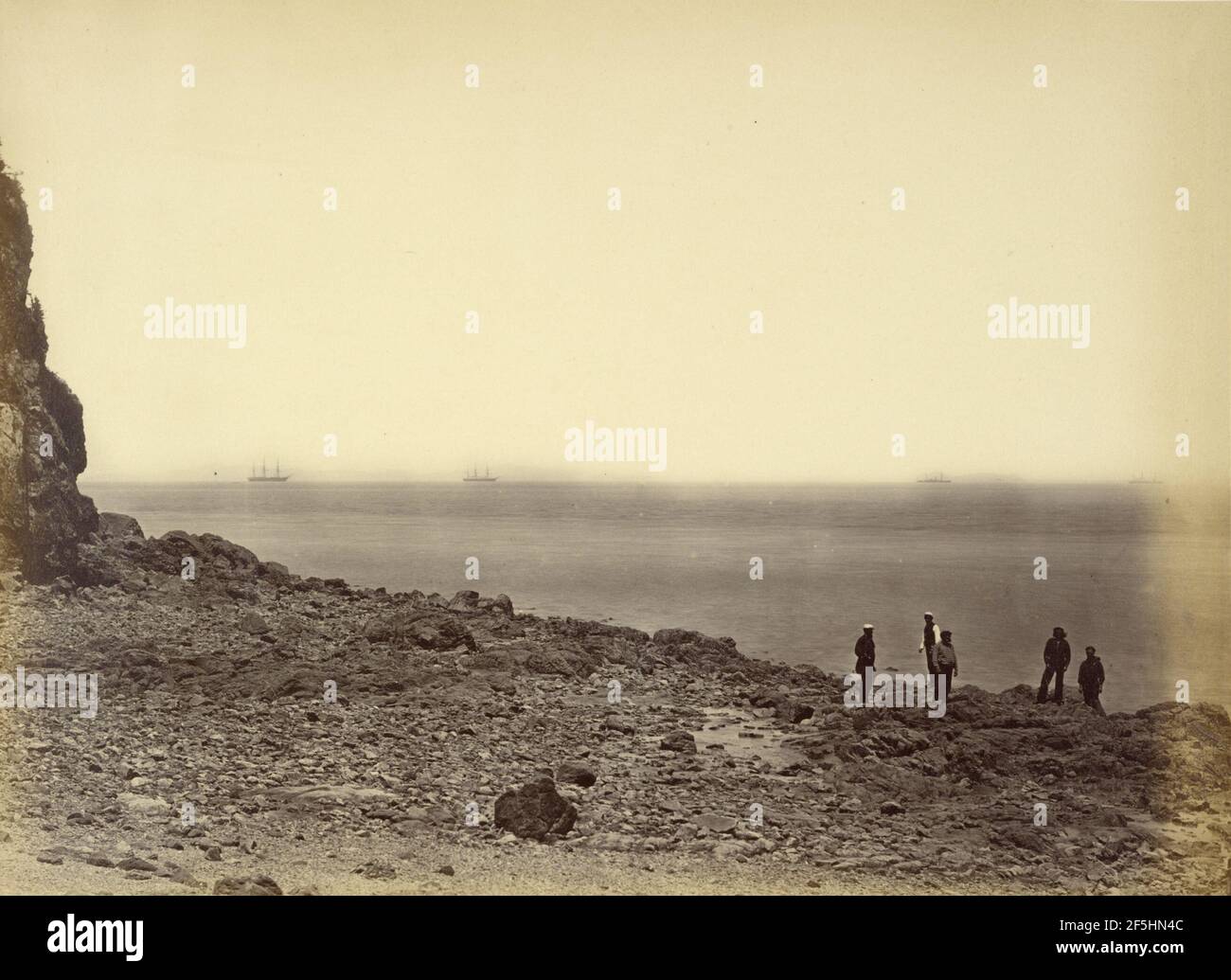 View of shore with ships on horizon and five figures standing on beach ...