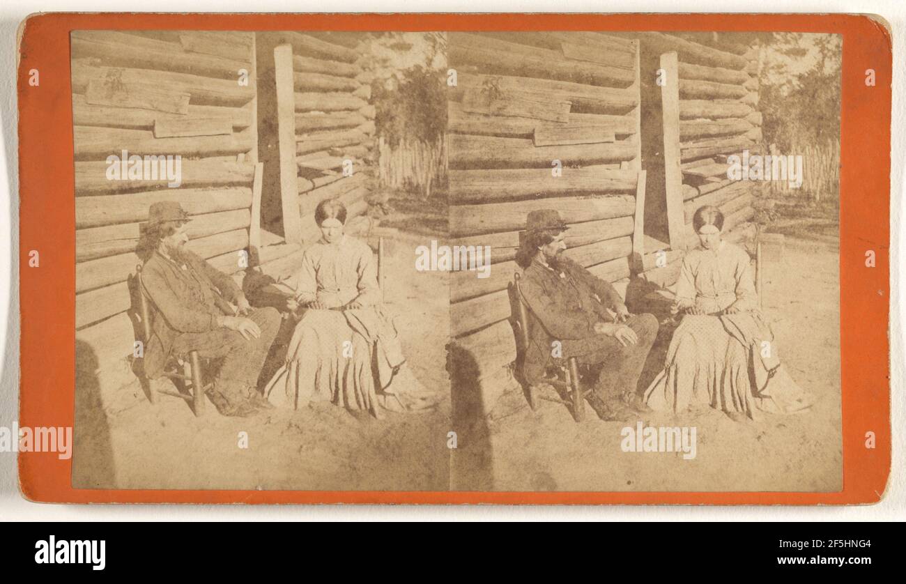 Man and woman seated in front of log cabin. Jerome Nelson Wilson ...