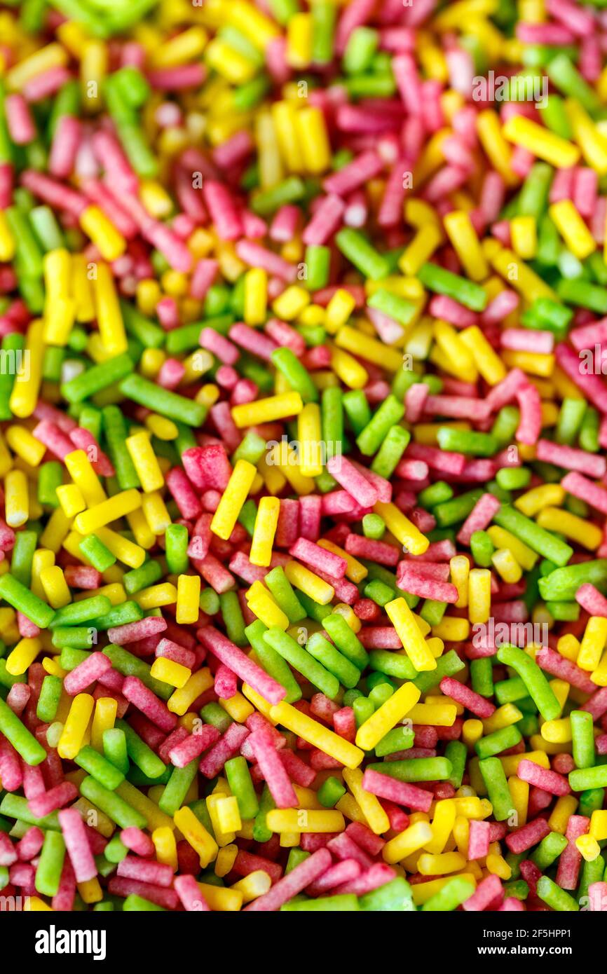 Full-frame macro top view of rainbow sprinkle pastry product ...