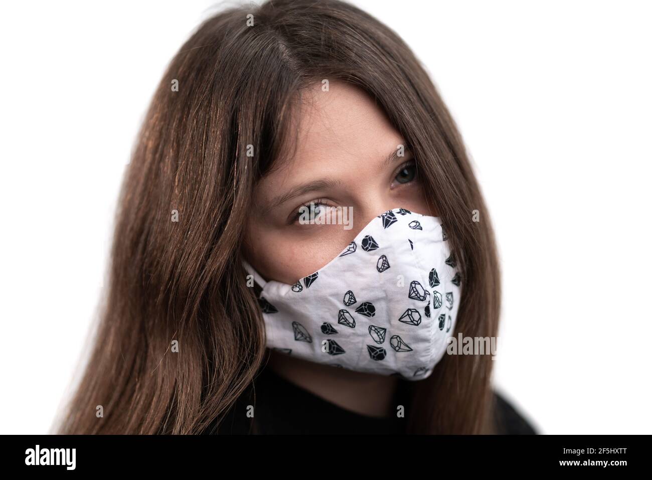 Beautiful young woman posing with mask, wearing black studio shot on ...