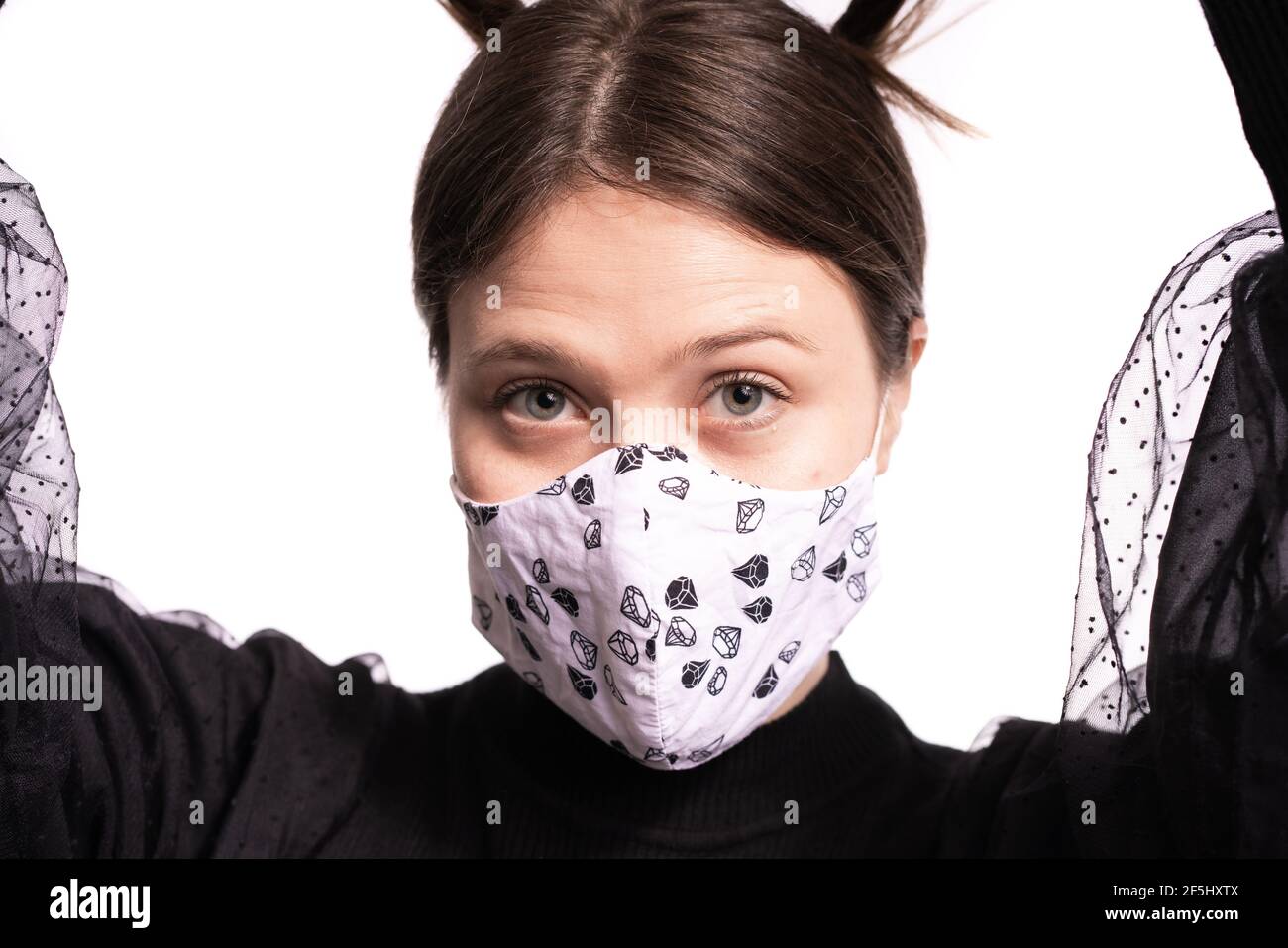 Beautiful young woman posing with mask, wearing black studio shot on ...