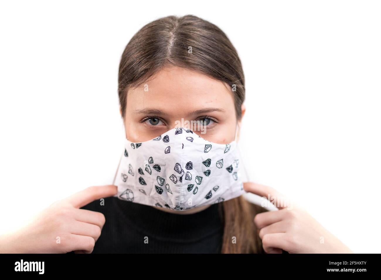 Beautiful young woman posing with mask, wearing black studio shot on ...