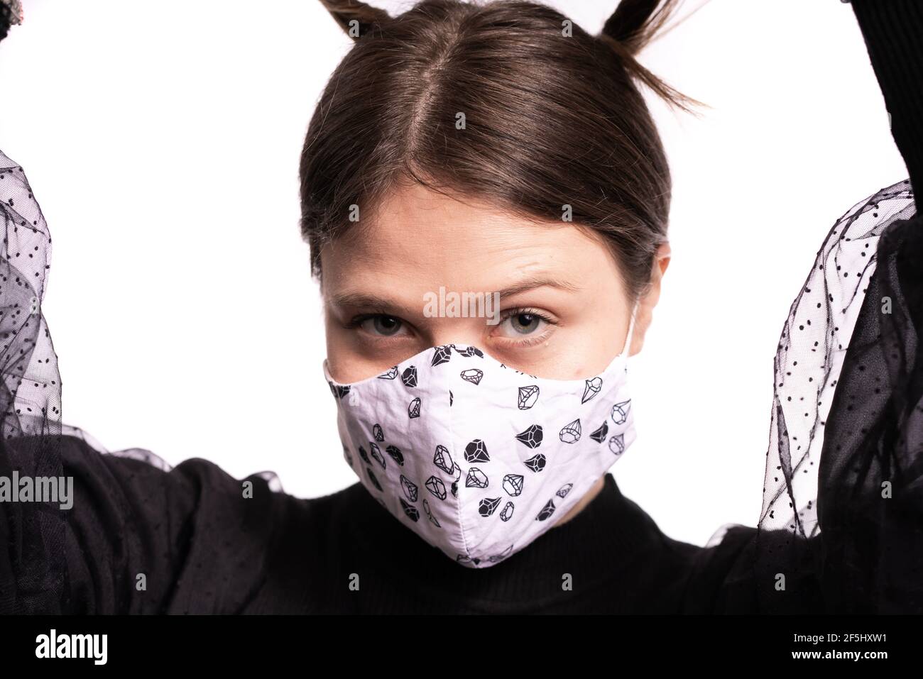 Beautiful young woman posing with mask, wearing black studio shot on ...