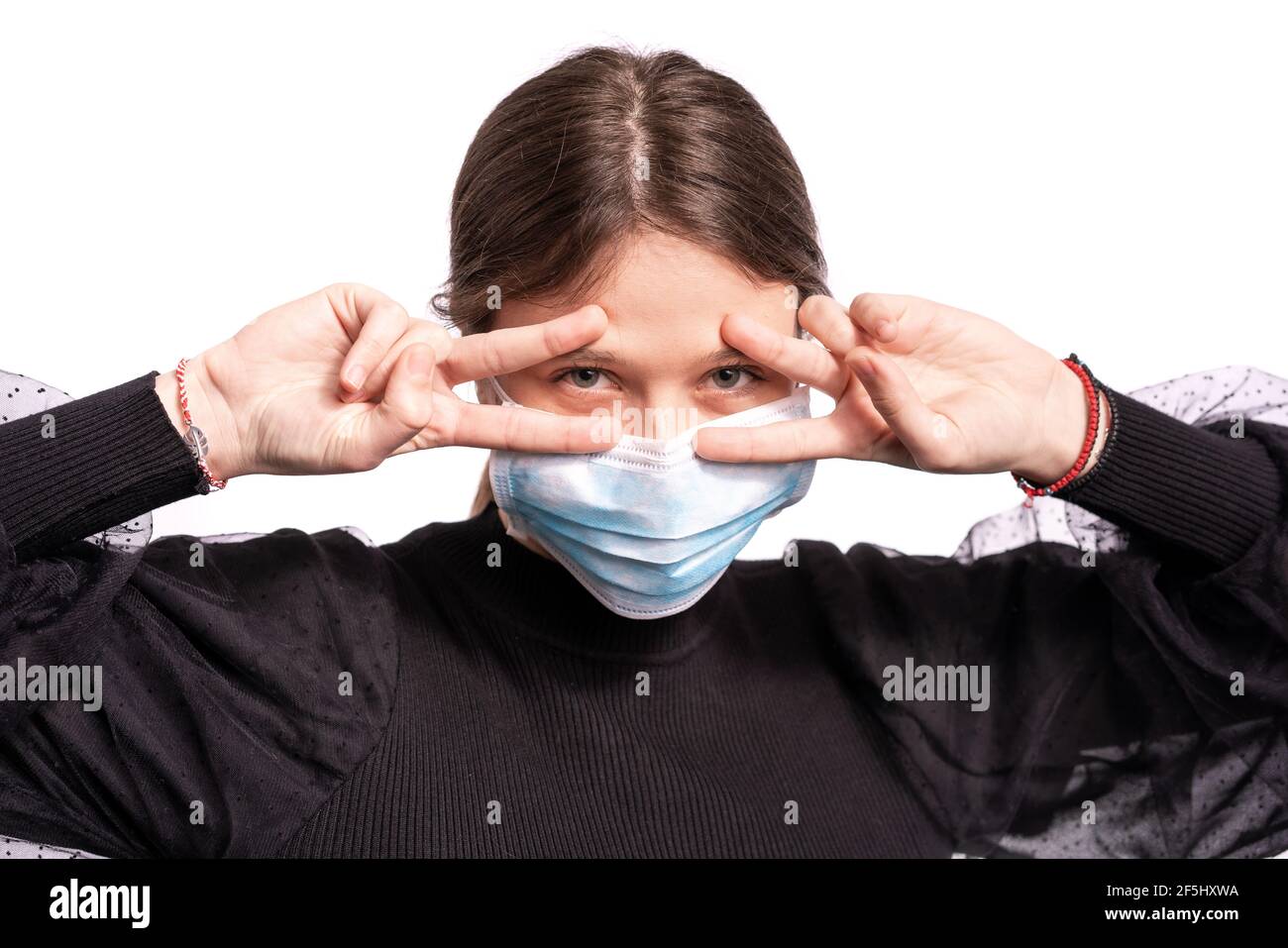 Beautiful young woman posing with mask, wearing black studio shot on ...