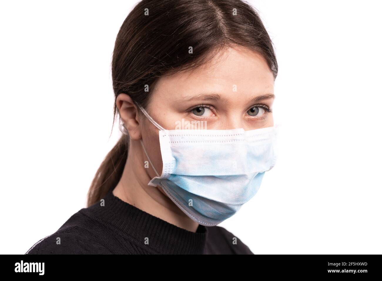 Beautiful young woman posing with mask, wearing black studio shot on ...