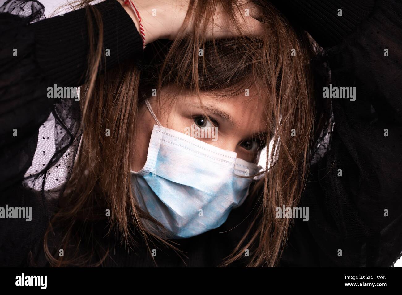 Beautiful young woman posing with mask, wearing black and pull hair ...