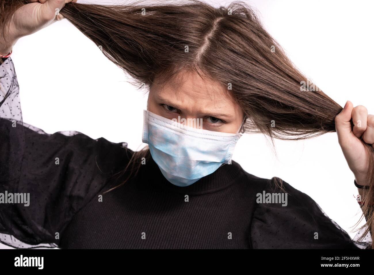 Beautiful young woman posing with mask, wearing black and pull hair ...