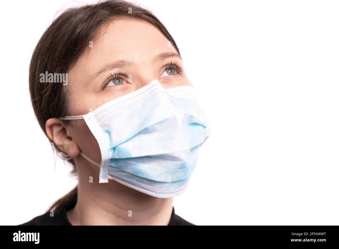 Beautiful young woman posing with mask, wearing black studio shot on ...