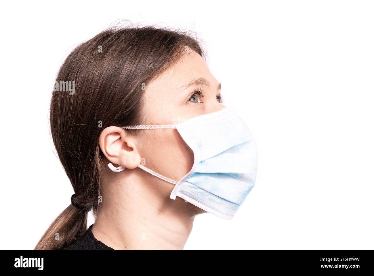 Beautiful young woman posing with mask, wearing black studio shot on ...
