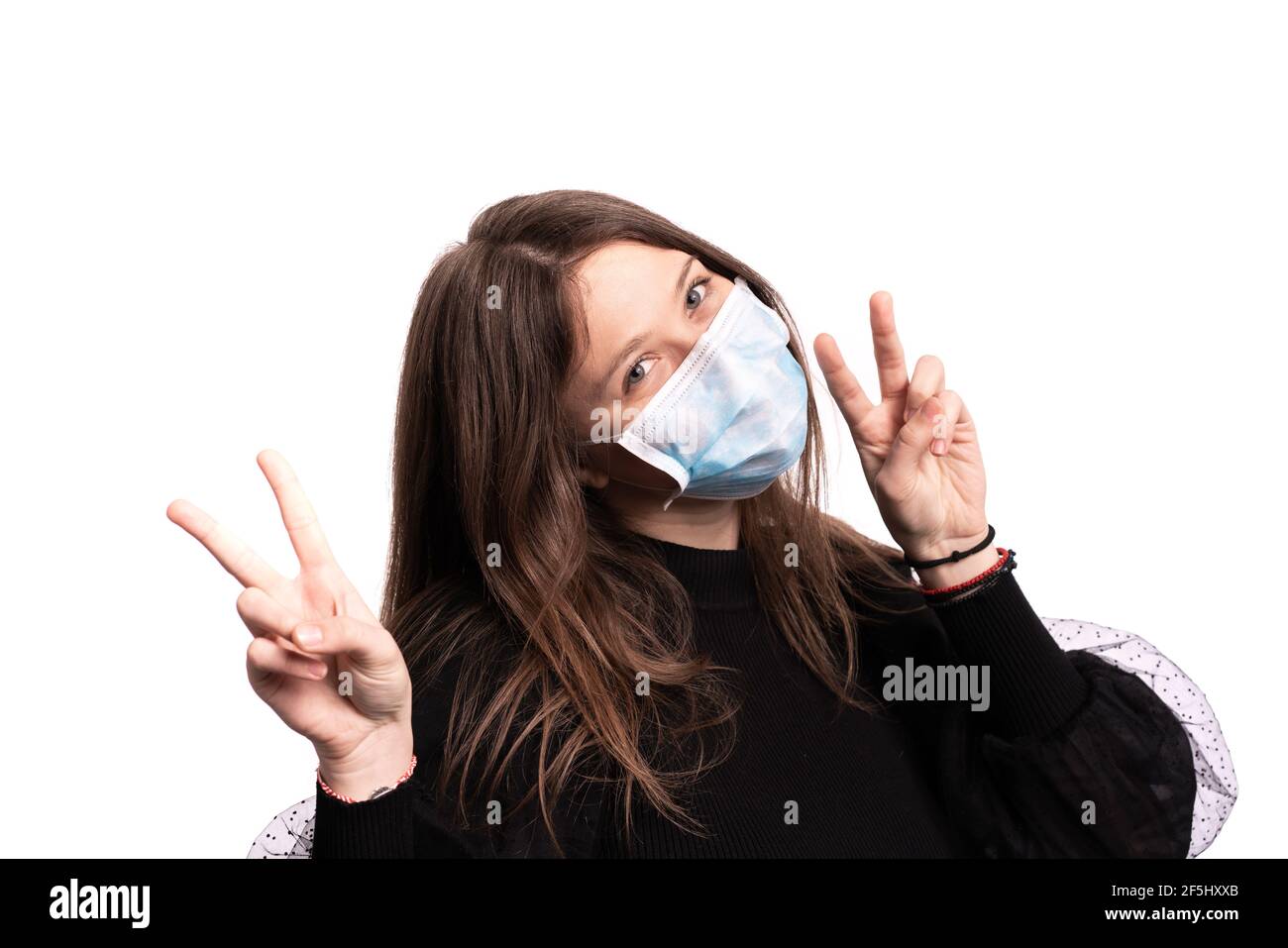 Beautiful young woman posing with mask, wearing black studio shot on ...