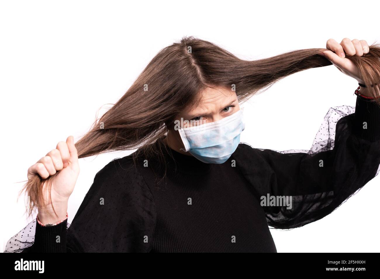 Beautiful young woman posing with mask, wearing black and pull hair ...