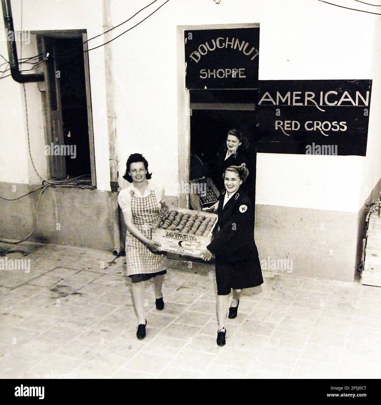 Red Cross girls carrying fresh doughnuts from an improvised kitchen ...